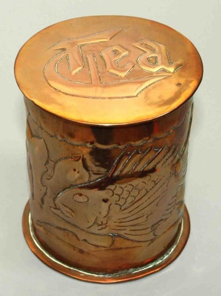 A Newlyn School copper tea caddy, the lidded cylindrical body embossed ...