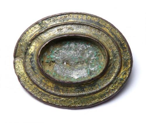 Roman glass centre-boss brooch. An oval plate brooch with a raised collar at the centre to ...
