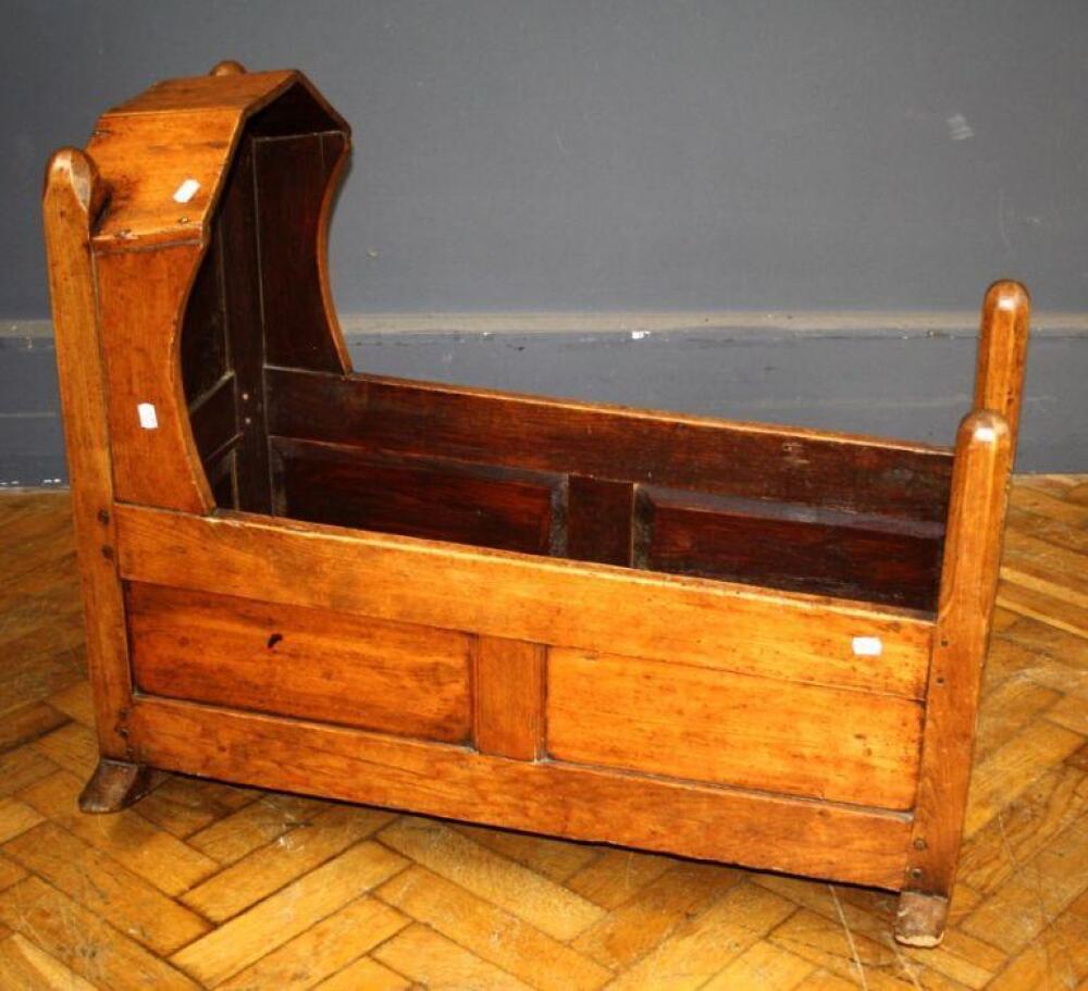 A 19th century pitched pine rocking cradle, of pegged and panel ...