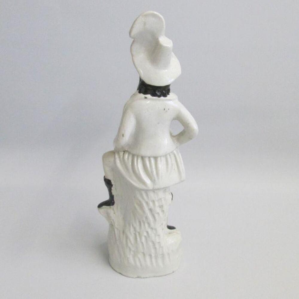 A Staffordshire white and gilt figure of a Huntsman, standing with his ...