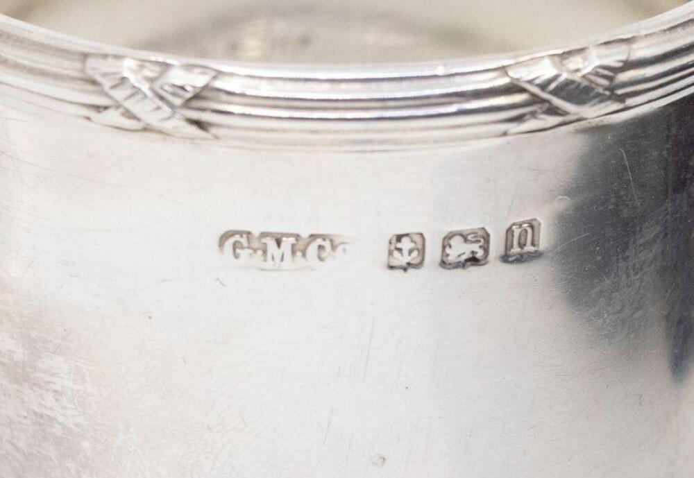 A matched set of six George V silver napkin rings, with ribbon tied ...