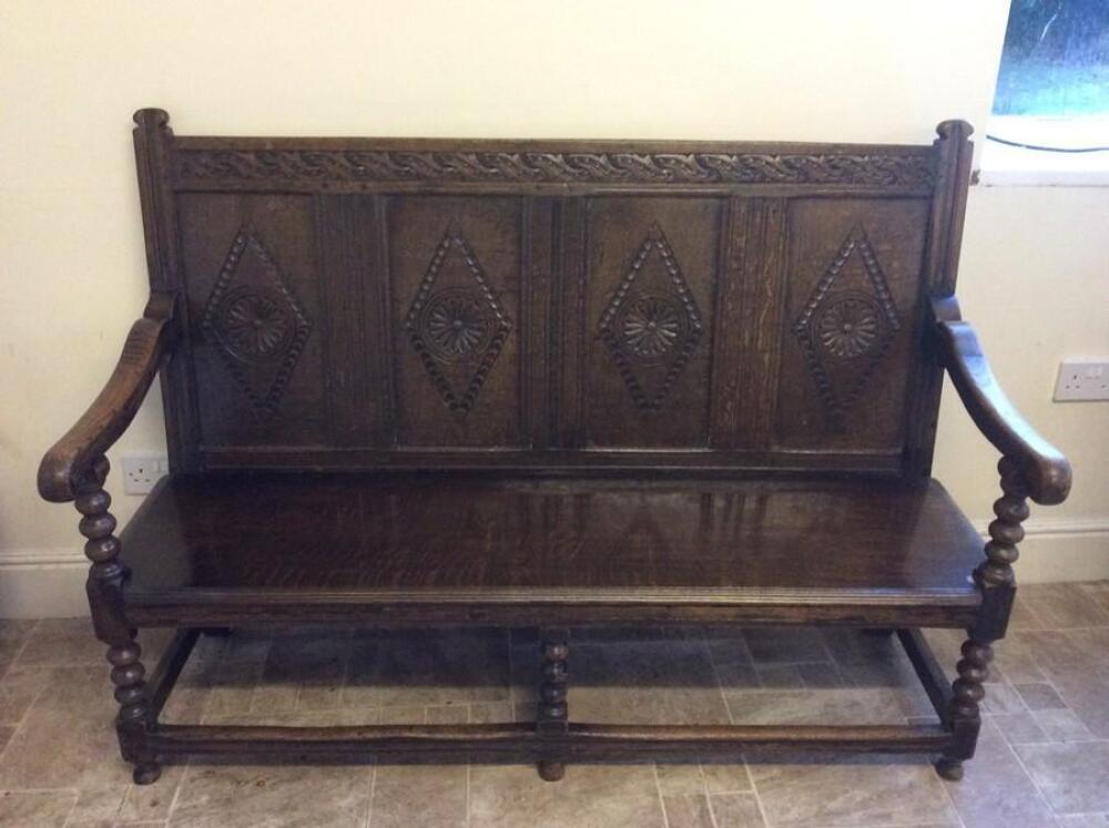 A Jacobean style carved oak settle, probably late 19th Century, carved ...