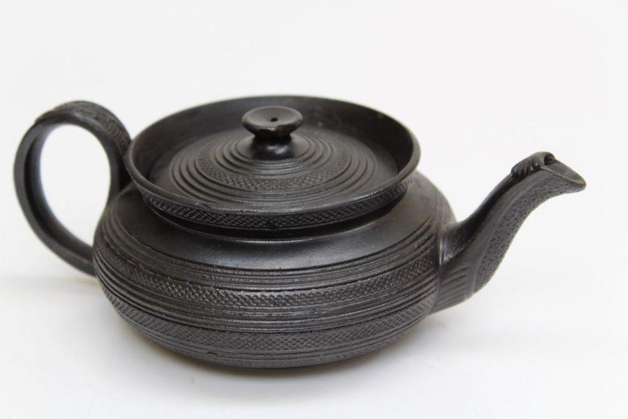 An early 19th century Staffordshire black basalt squat teapot, simple ...