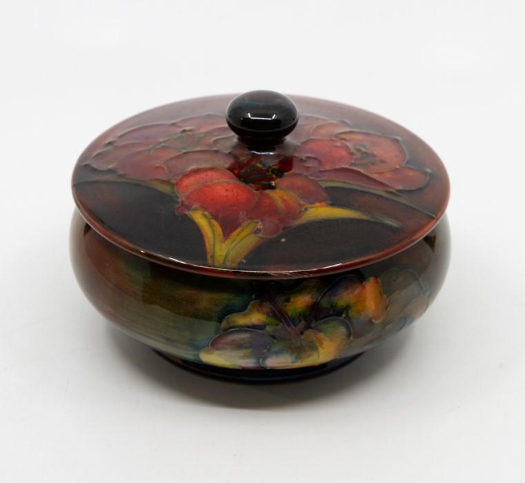 A Moorcroft flambe Lily pattern footed circular bowl and cover ...