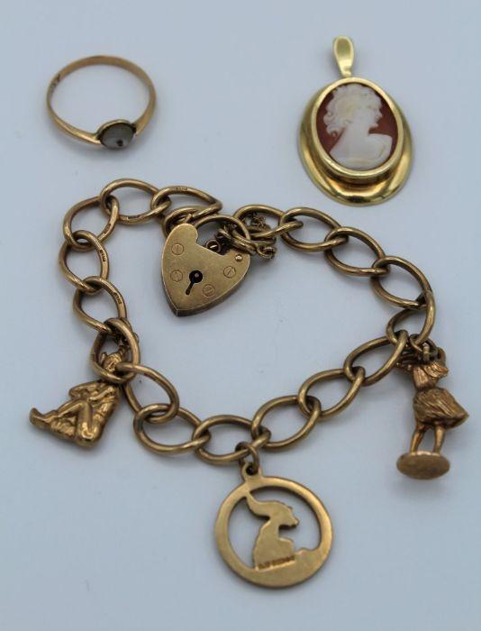 A 9ct yellow gold oval link charm bracelet suspending three fairy/pixie ...
