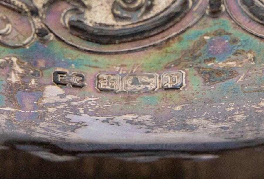 An Edwardian silver bowl with ornate embossed floral design and ...