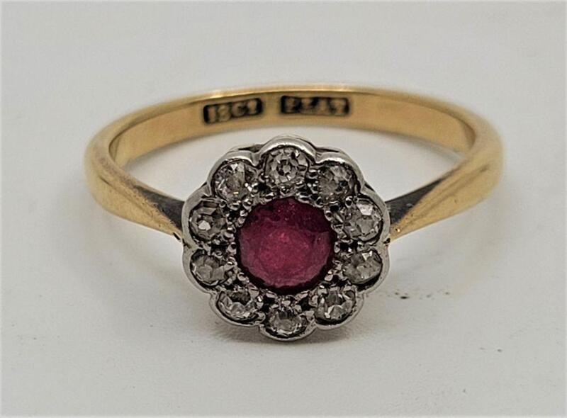An 18ct. gold, platinum, ruby and diamond cluster ring, set mixed round ...