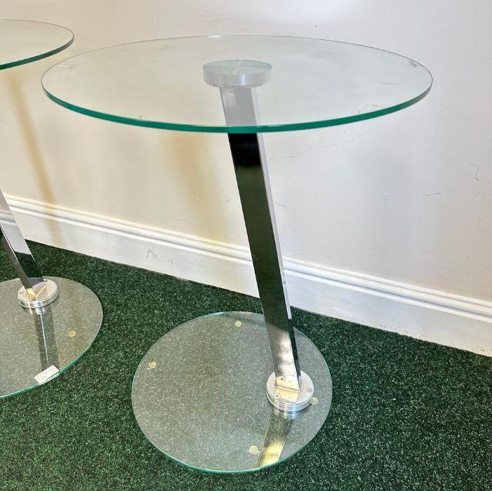 A pair of chrome side tables of circular form with angled supports ...