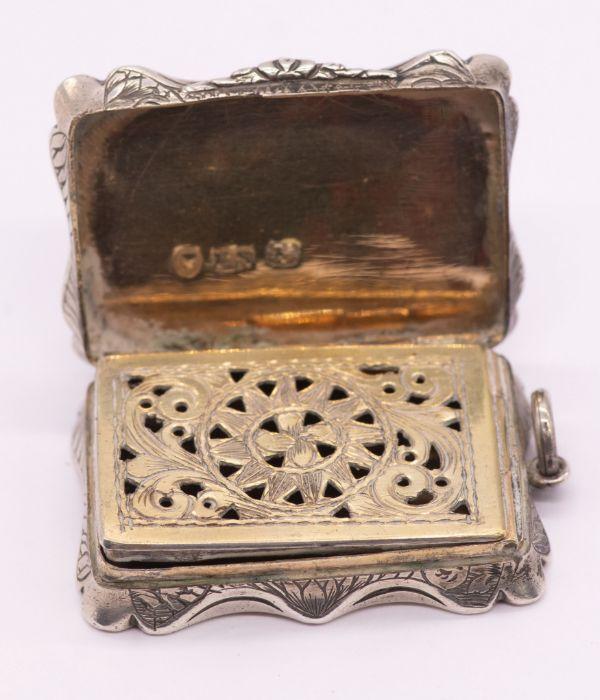 A Victorian silver vinaigrette, cartouche shaped engraved with profuse ...