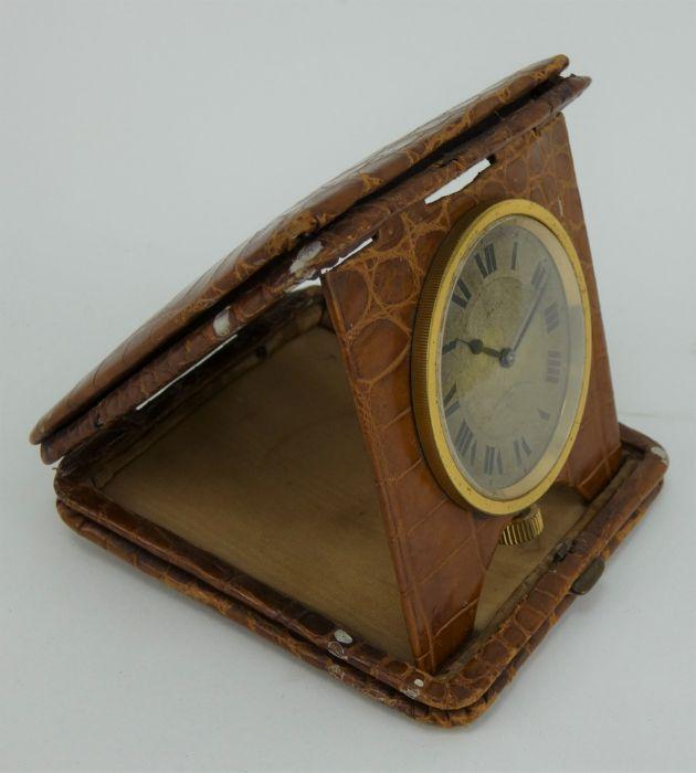 An early 20th century folding 8 day travel clock in mock croc leather ...