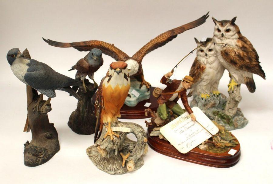 A collection of bird and owl figures, large, some on wooden stands ...