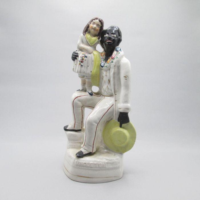 A Staffordshire portrait figure of Uncle Tom and Young Eva, Tom seated ...
