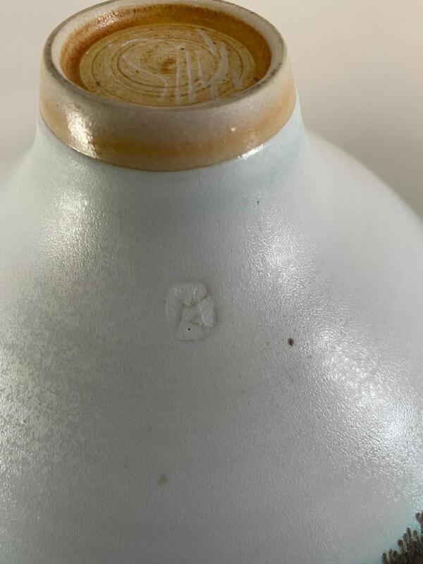 A porcelain footed bowl after Lucie Rie with bronzed decoration to rim ...