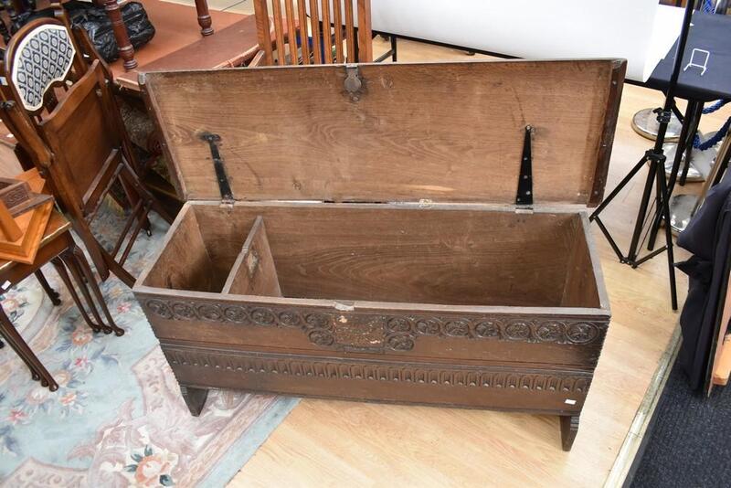 A mid-17th century dark oak coffer, made from single timbers, carving ...
