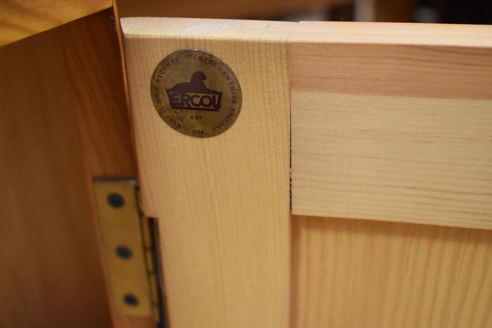 A late 20th century Ercol pine corner unit with two display shelves and ...