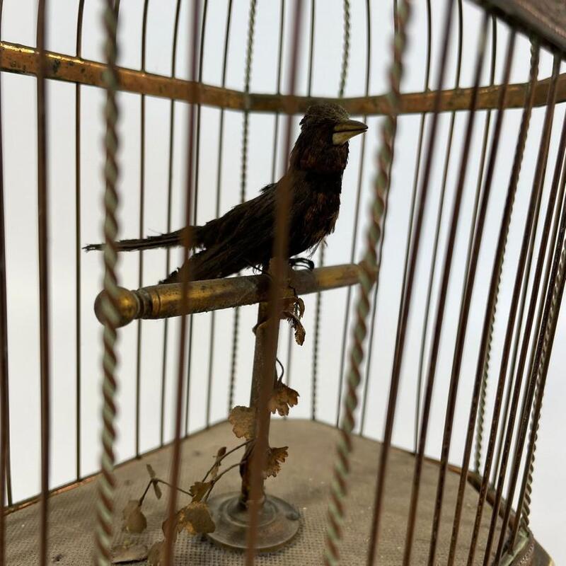 A singing bird cage automaton. In an octagonal domed cage on a gilt ...