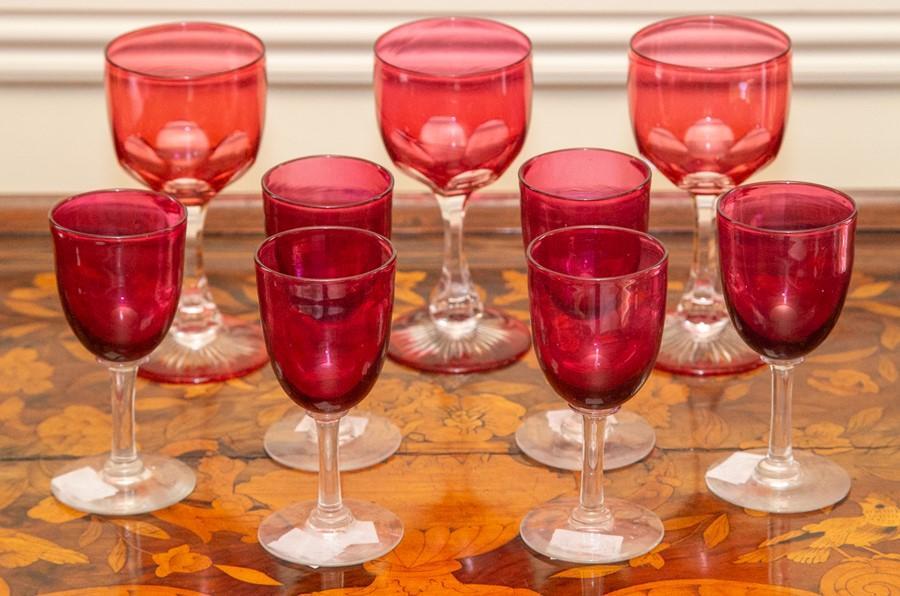 Nine various cranberry and ruby glass drinking glasses. (9)