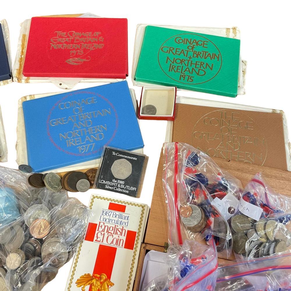 A collection of coins, including six year sets and commemorative crowns ...