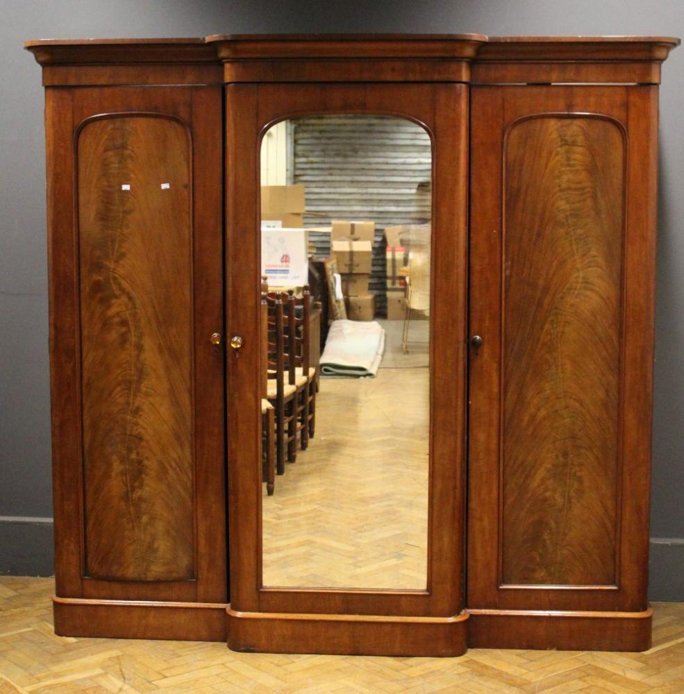 A Victorian figural mahogany breakfront compactum wardrobe, having a ...
