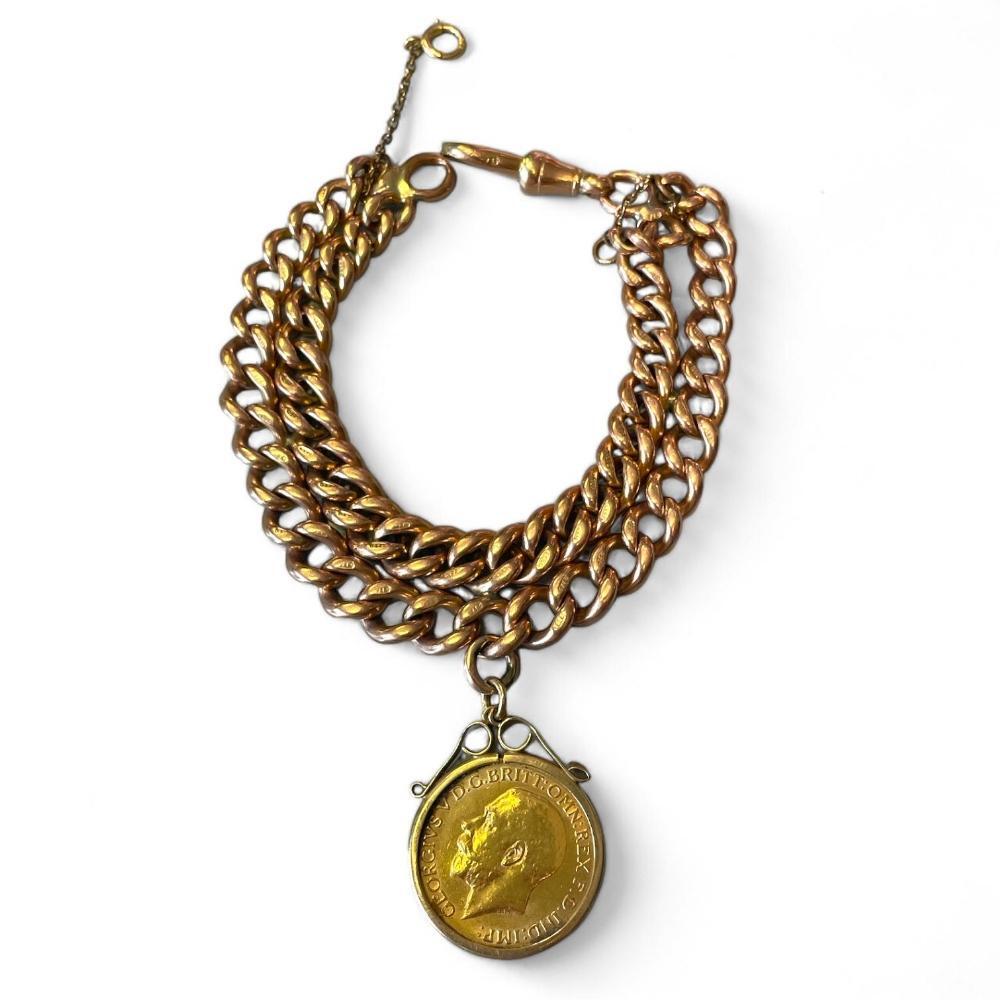 A George V 1914 full UK gold sovereign, in a 9ct gold clip frame on a ...