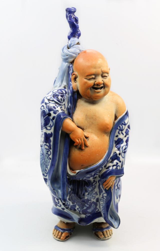 A Japanese blue and white painted and biscuit porcelain standing figure ...