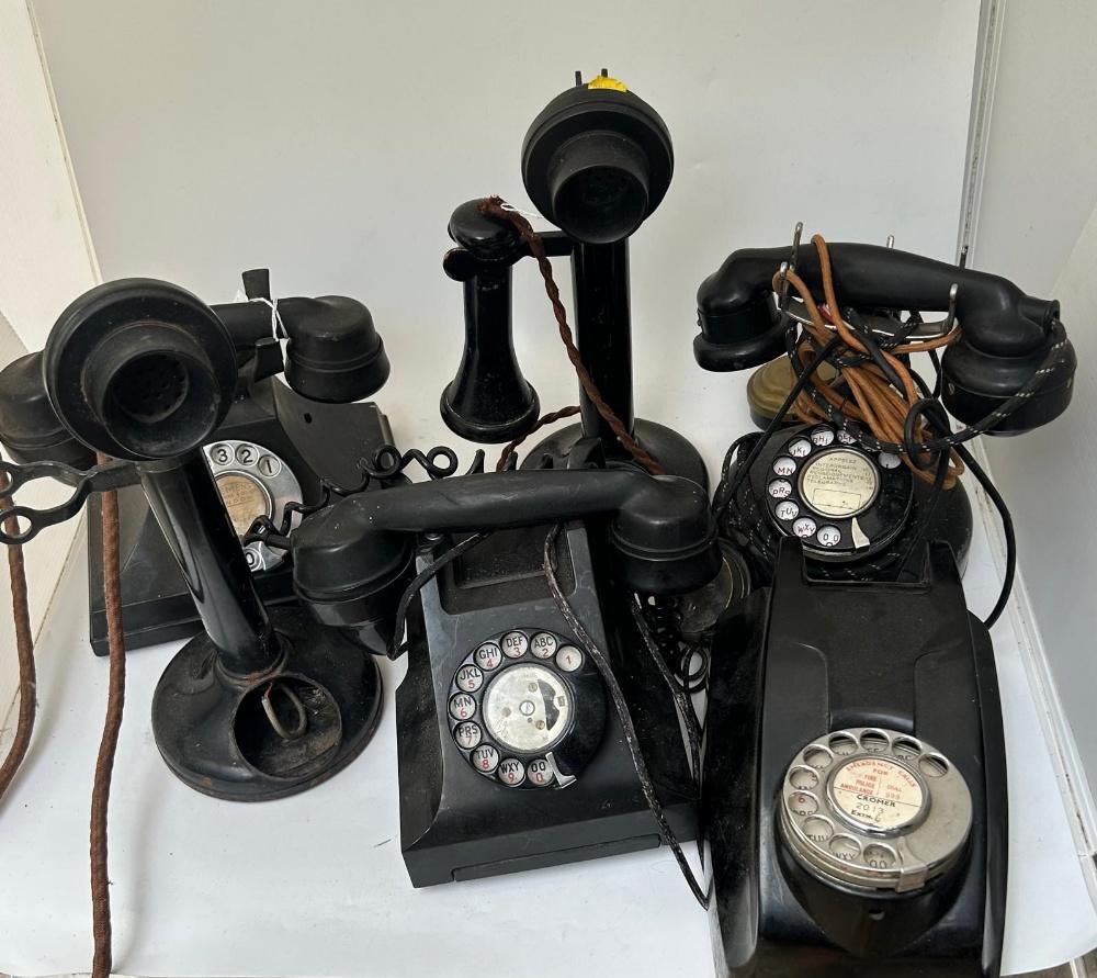 A large collection of vintage black bakelite telephones