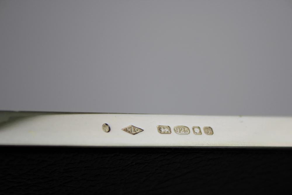 A silver photograph frame with ribbed border decoration and strut back ...