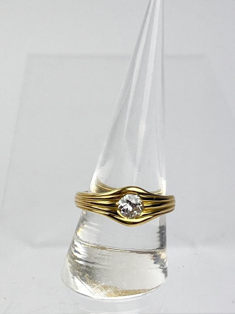 A diamond ring, inset with a circular cut diamond, to a fluted mount ...