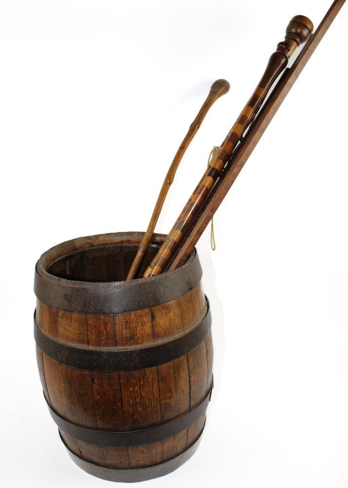 An early 20th century coopered oak barrel shaped oval stick stand, with ...