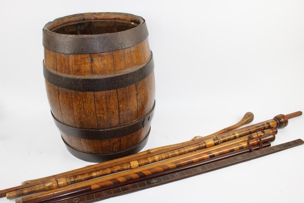 An early 20th century coopered oak barrel shaped oval stick stand, with ...