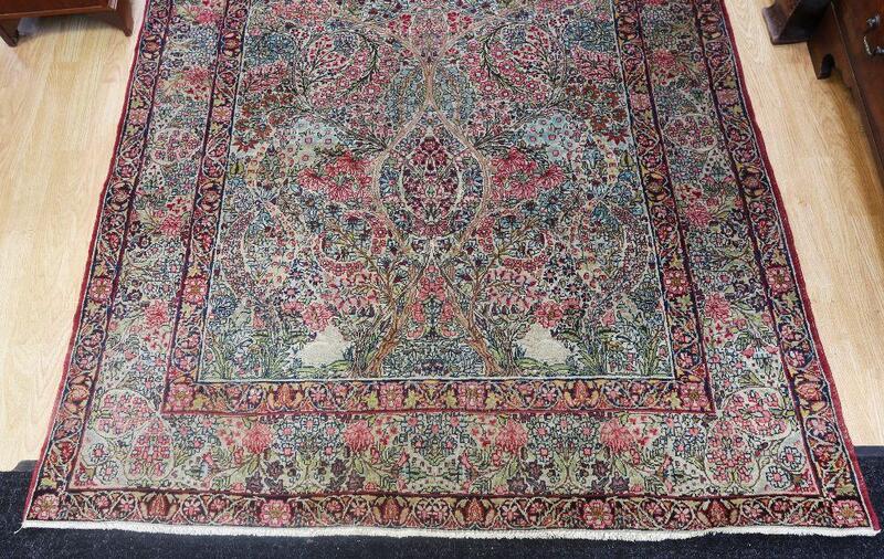 A Kirman rug, South East Persia, circa 1900, the ivory toned mihrab ...