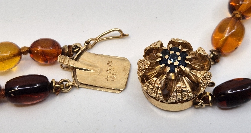 A two string graduated amber bead necklace, fashioned from ovoid beads ...