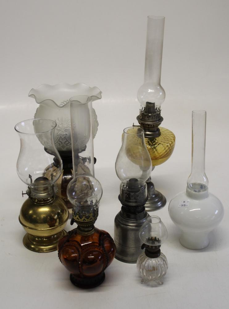 Six, largely Edwardian paraffin lamps, chimnies and shades
