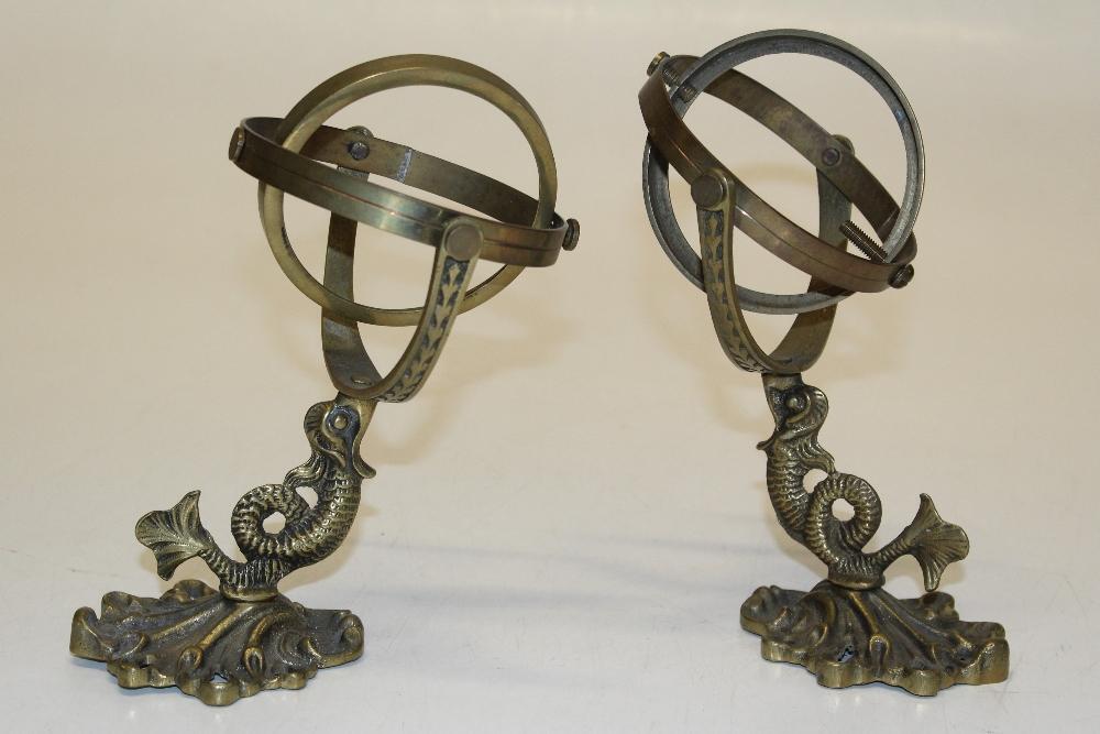 A pair of early 20th century ships gimbals, supported by Rococo fishes ...