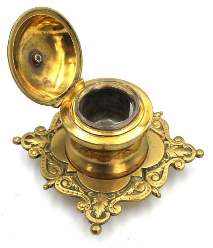 A 20th century brass inkwell, elaborately shaped with scrolled form ...