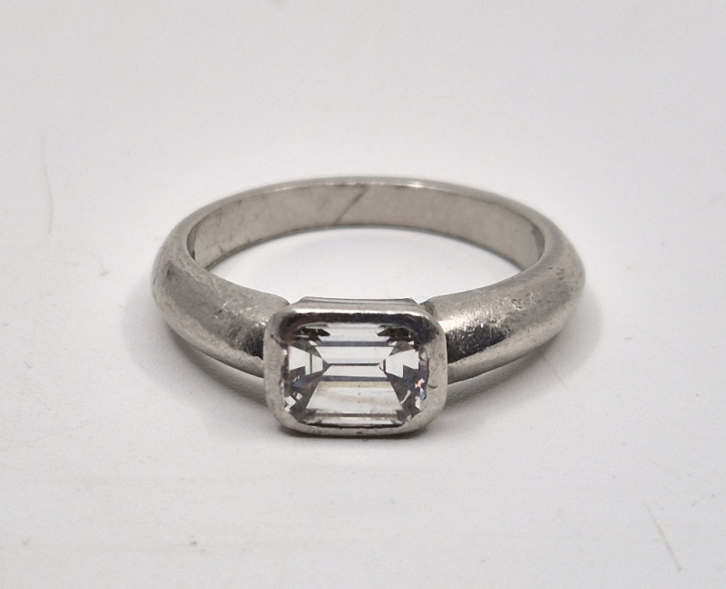 A platinum single stone diamond ring, having single emerald cut diamond ...