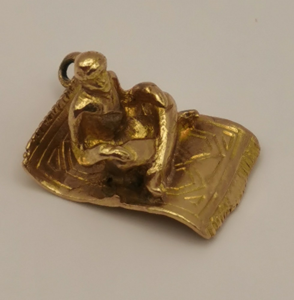 A 9ct gold Genie on a flying carpet charm, 3.1g