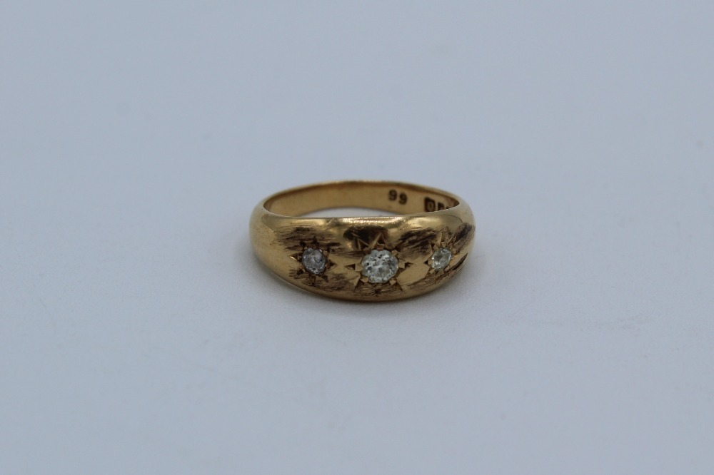 An 18ct gold ring, set three diamonds in rub over mount. London 1919, 5gms