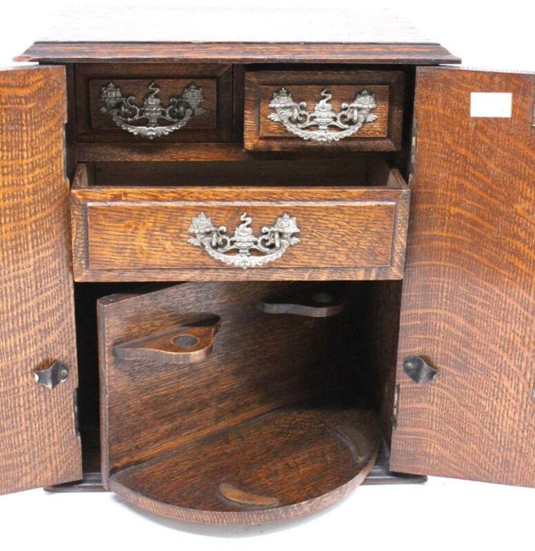 A 20th century oak tobacco stand and cupboard, with hinged doors ...