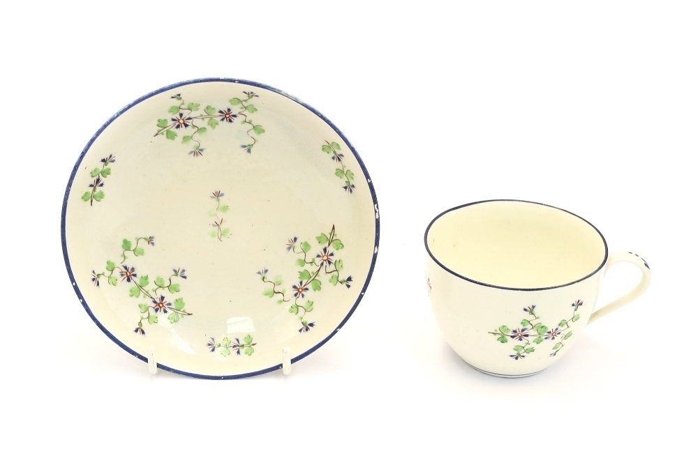 A Pinxton porcelain teacup and saucer, painted with floral sprig ...