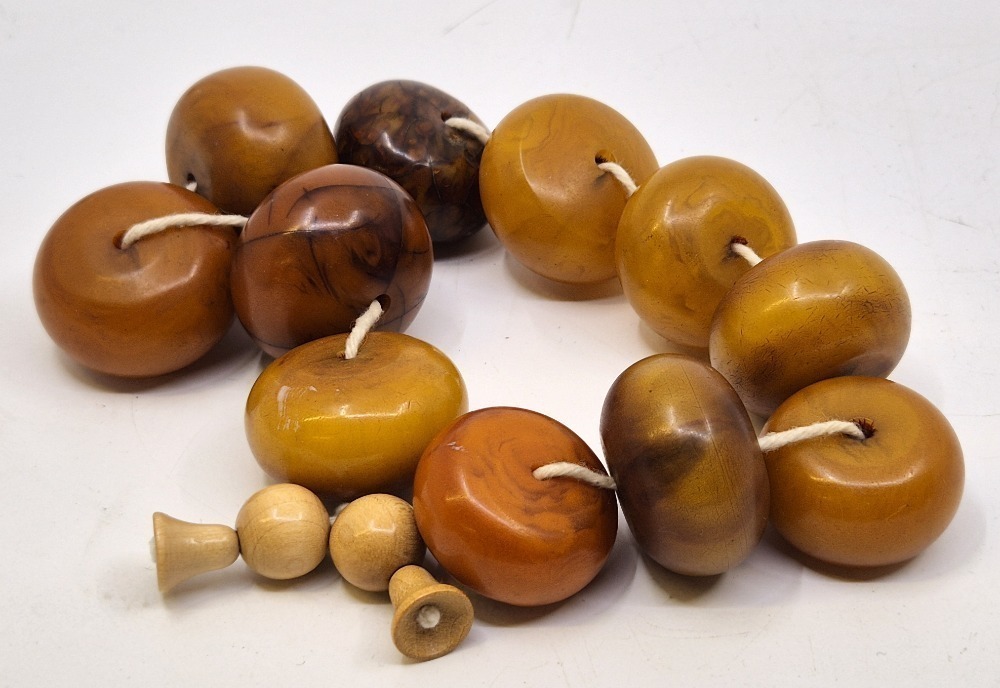 A string of eleven large amber beads, of varying shades of colour and ...