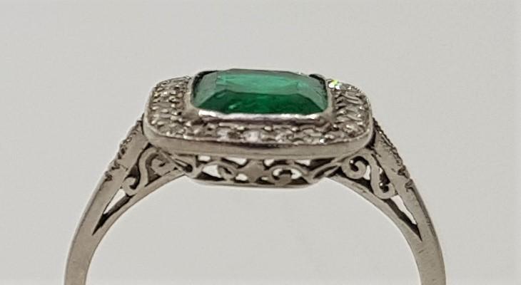 An Art Deco style precious white metal, diamond and emerald ring ...